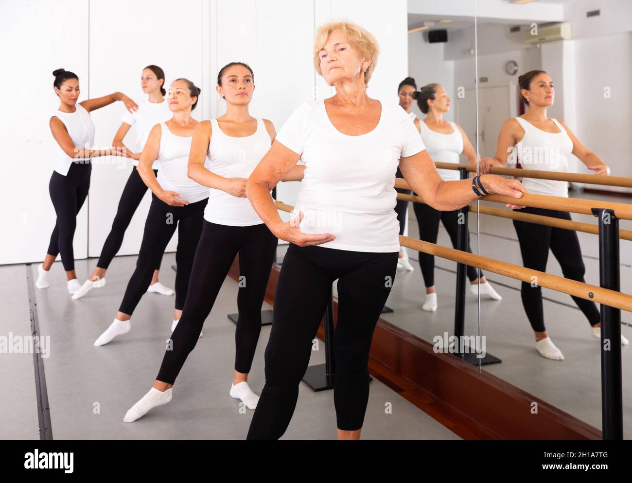Female choreographer and group of multiracial dancers in dance school ...