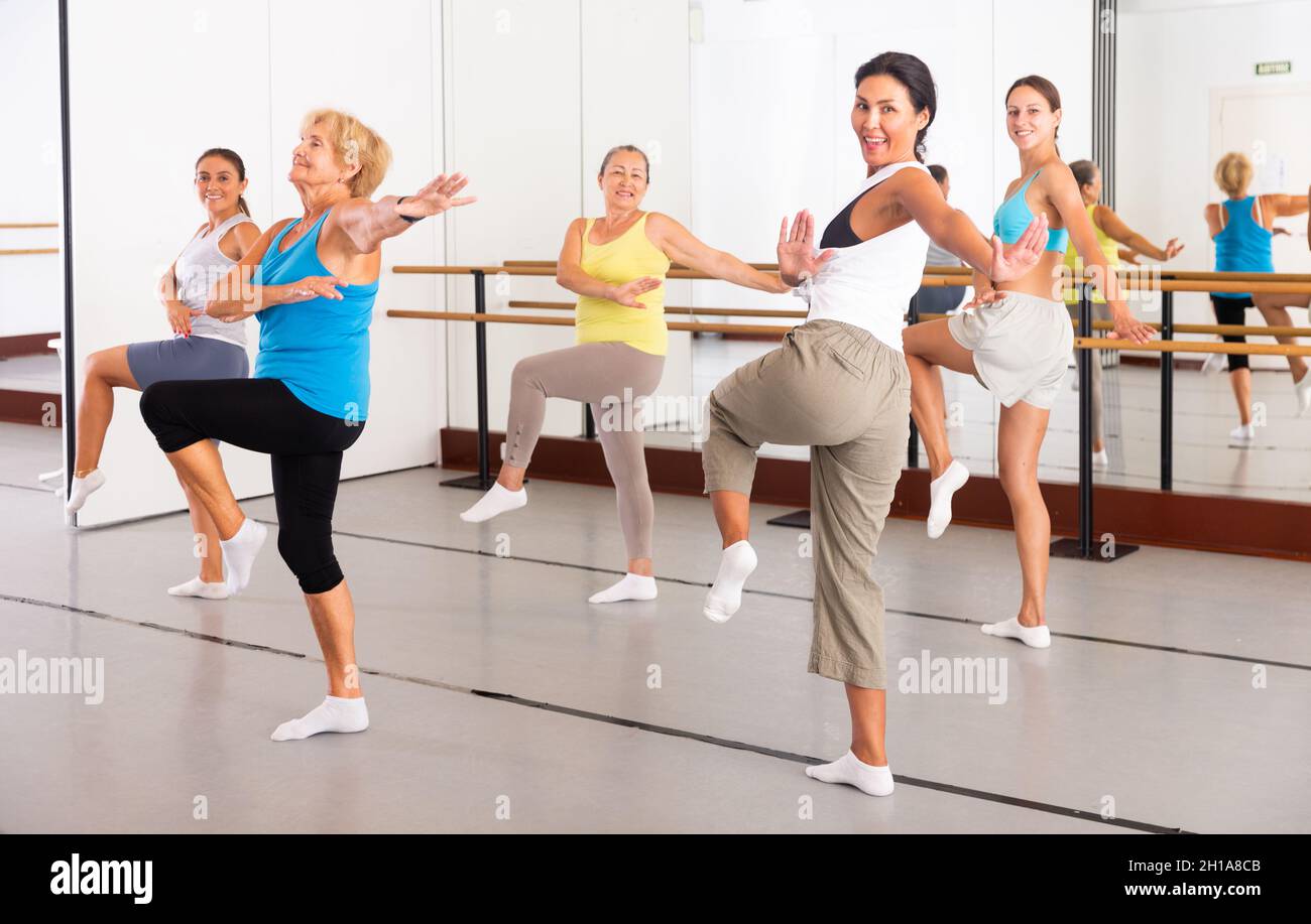 Women practicing vigorous dance movements in group dance class Stock ...