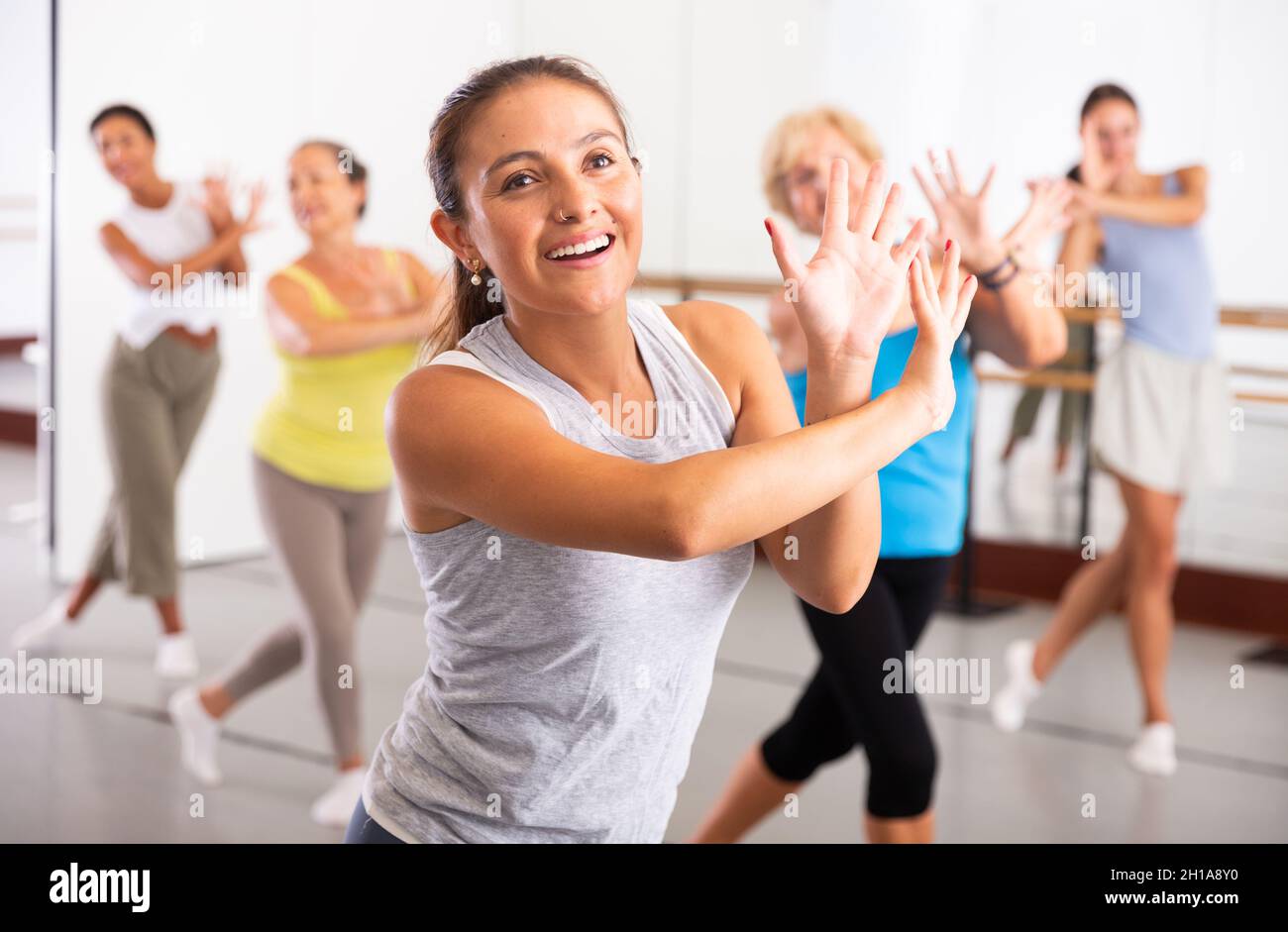 Latino girl dancing modern dance in studio with other dancers Stock ...