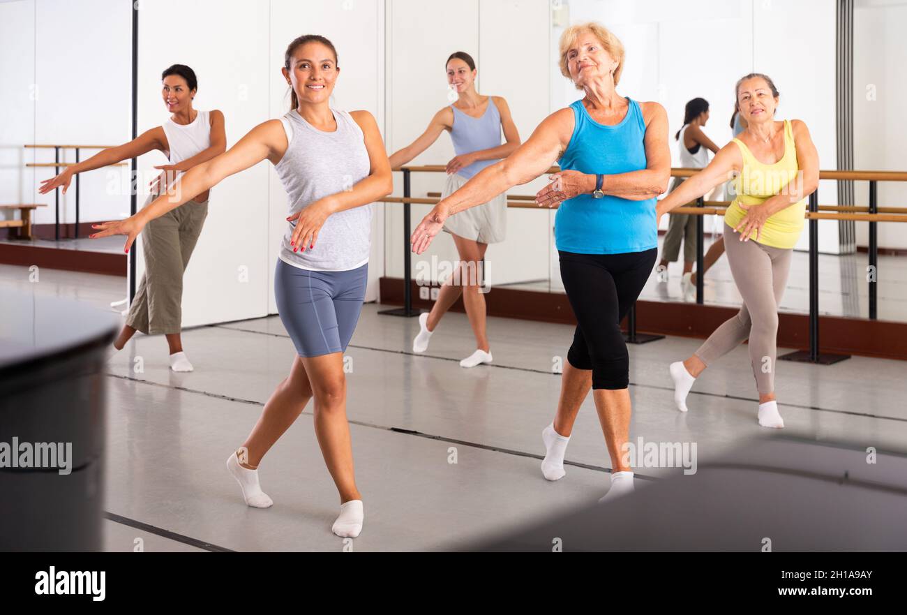 Positive women of different ages dancing strip plastic in dance class ...