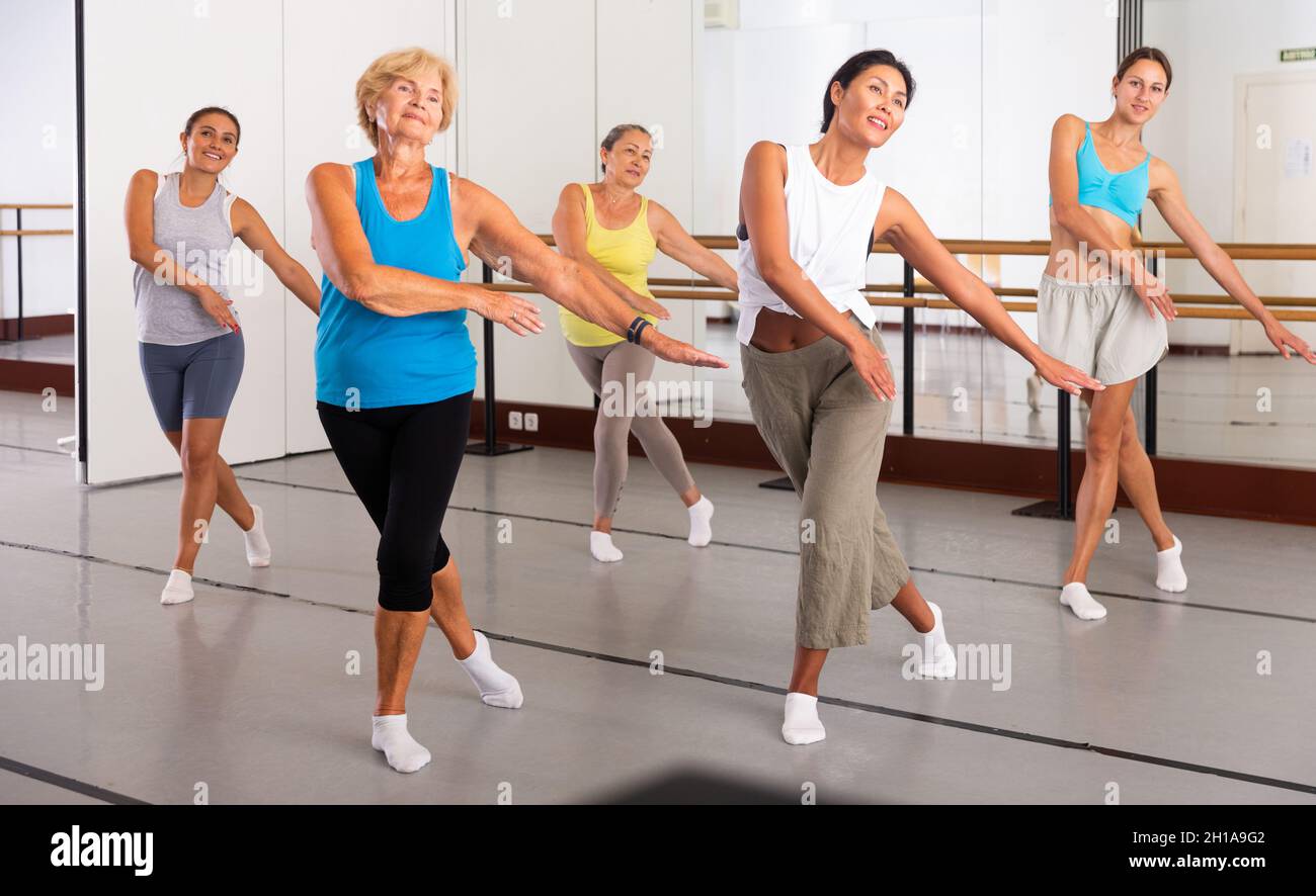 Group of happy women different ages practicing zumba in dance class ...