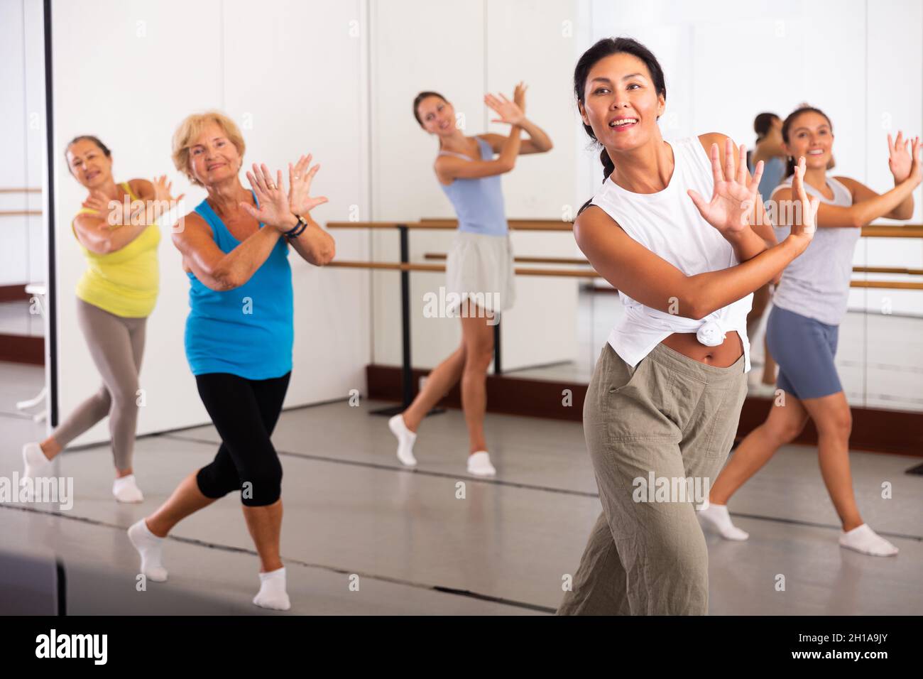 Positive women of different ages dancing strip plastic in dance class ...