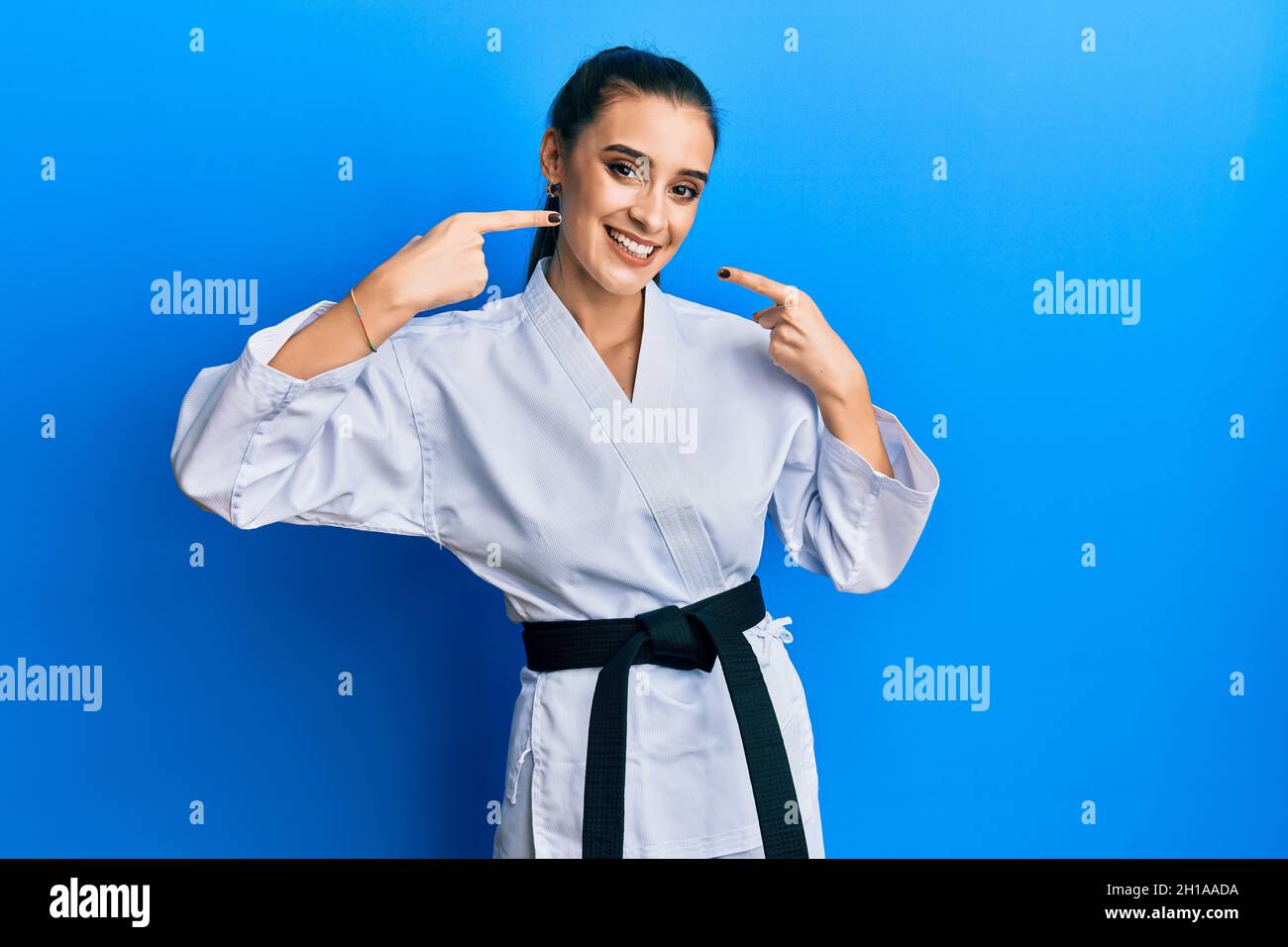 Beautiful brunette young woman wearing karate fighter uniform with ...