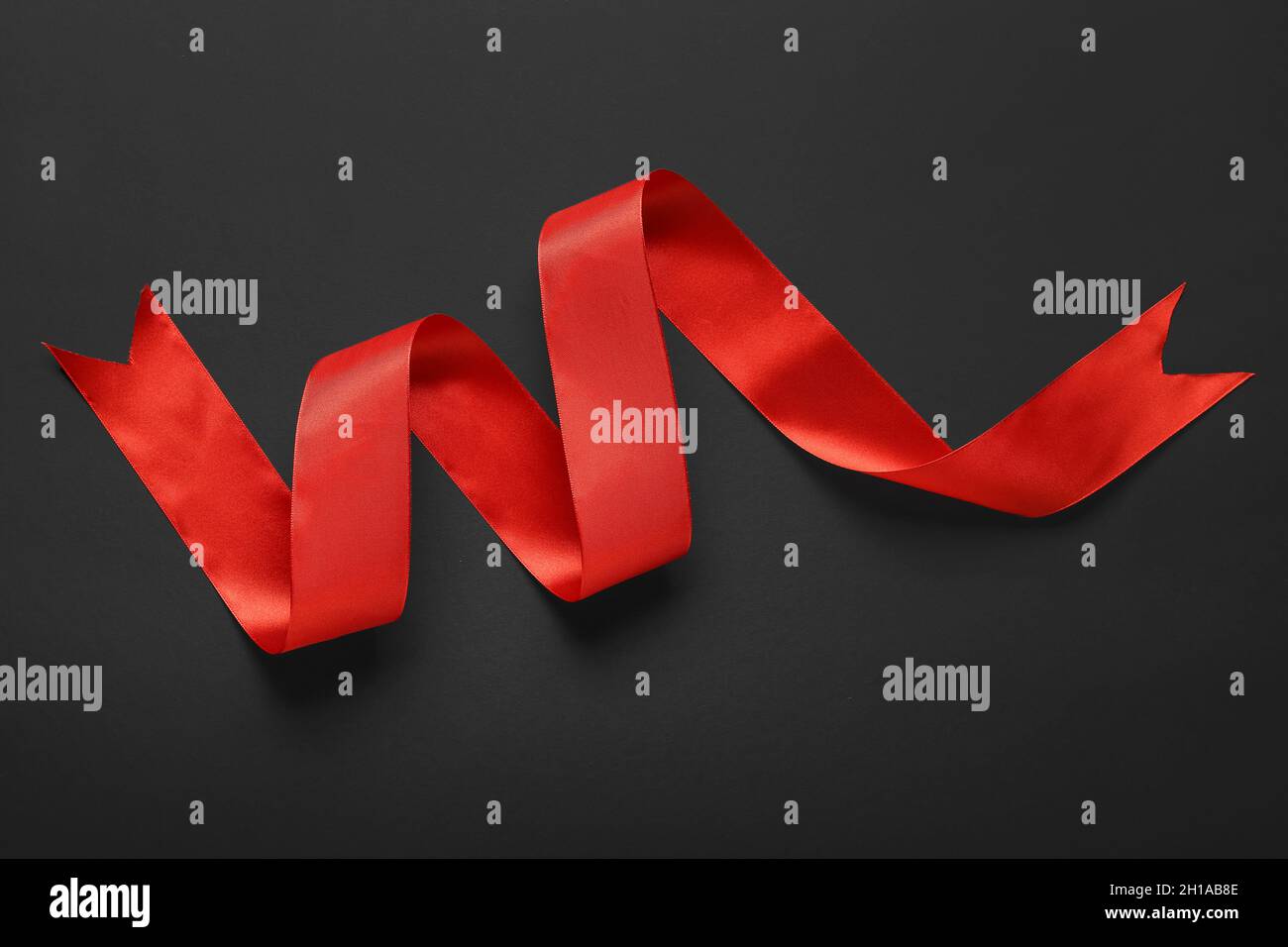 Shiny red ribbon on dark background Stock Photo - Alamy