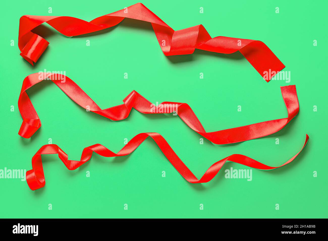 Shiny red ribbons on color background Stock Photo - Alamy