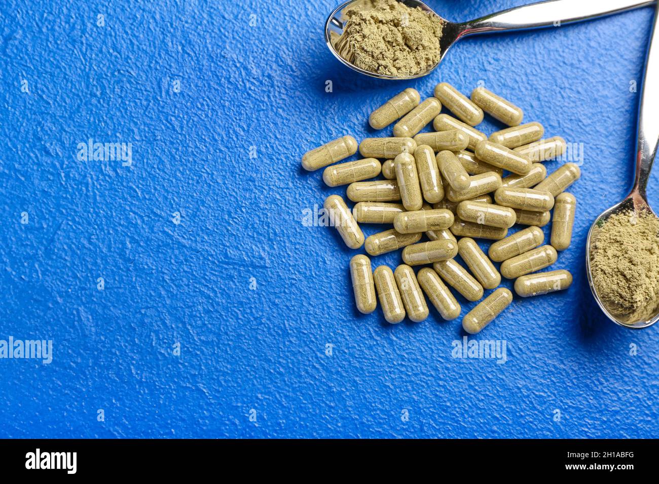 Spoons with vitamin K pills on color background Stock Photo - Alamy