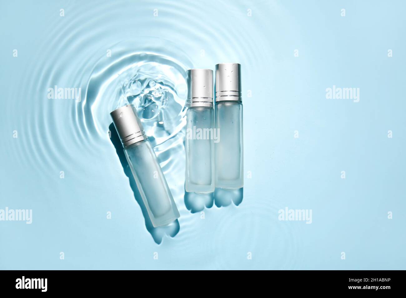 Bottles of cosmetic products in water on blue background Stock Photo ...