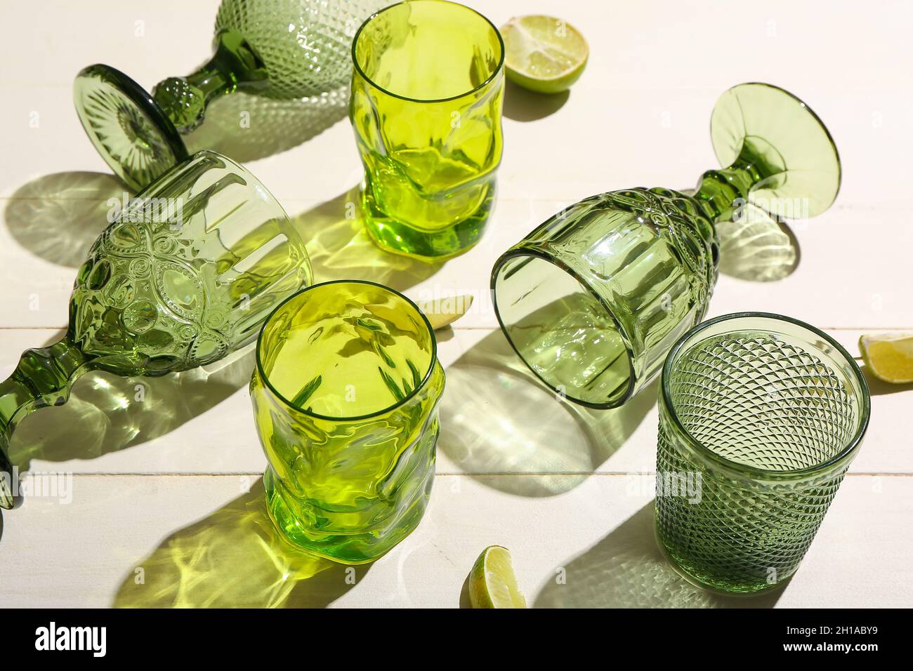 Beautiful empty glasses and lime on light wooden background, closeup ...