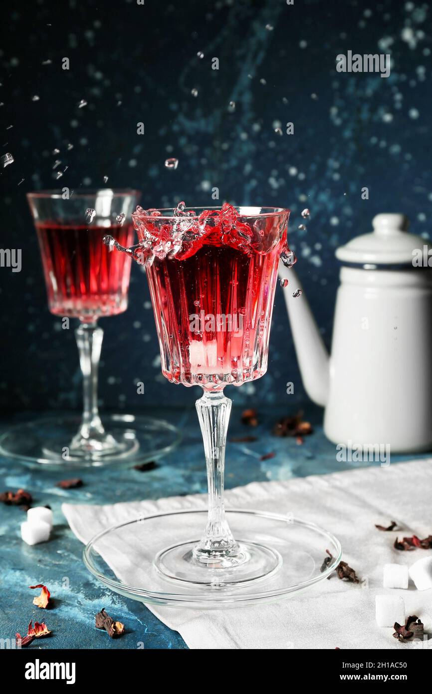 Glass of hot red tea with splash on table Stock Photo - Alamy