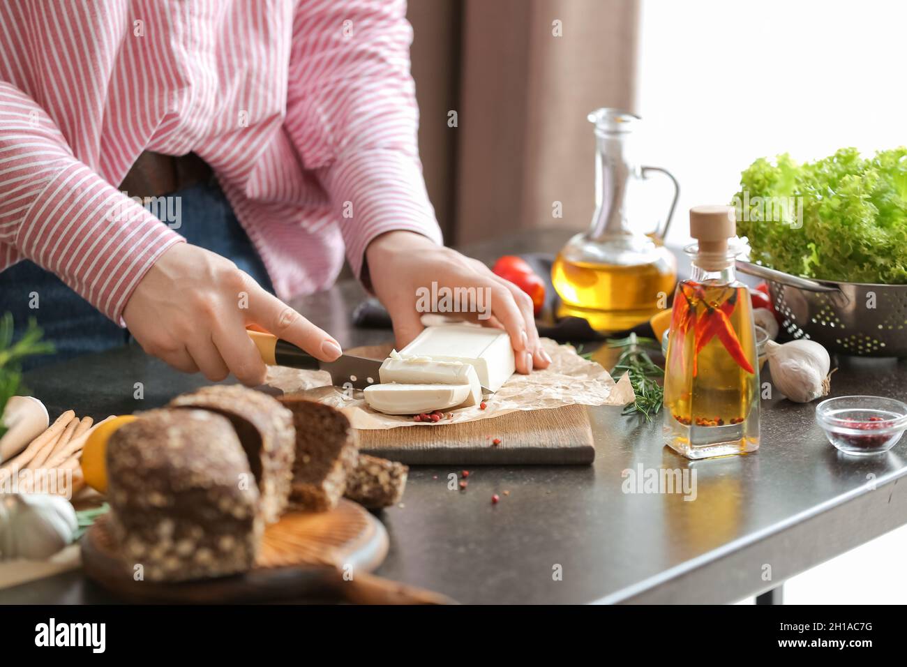 Woman cutting feta cheese hi-res stock photography and images - Alamy