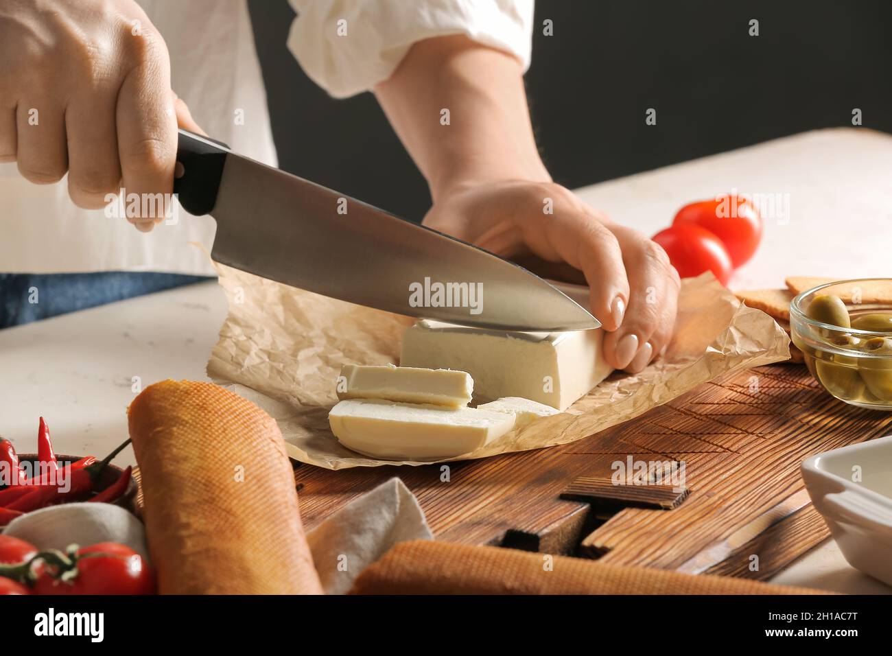 Woman cutting feta cheese hi-res stock photography and images - Alamy