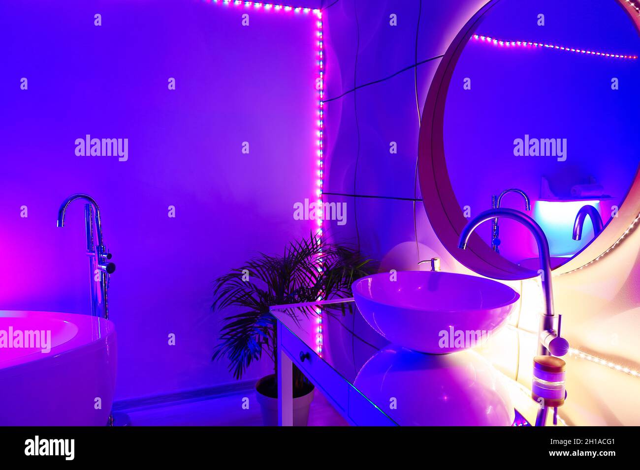Interior of stylish bathroom with neon lighting Stock Photo - Alamy