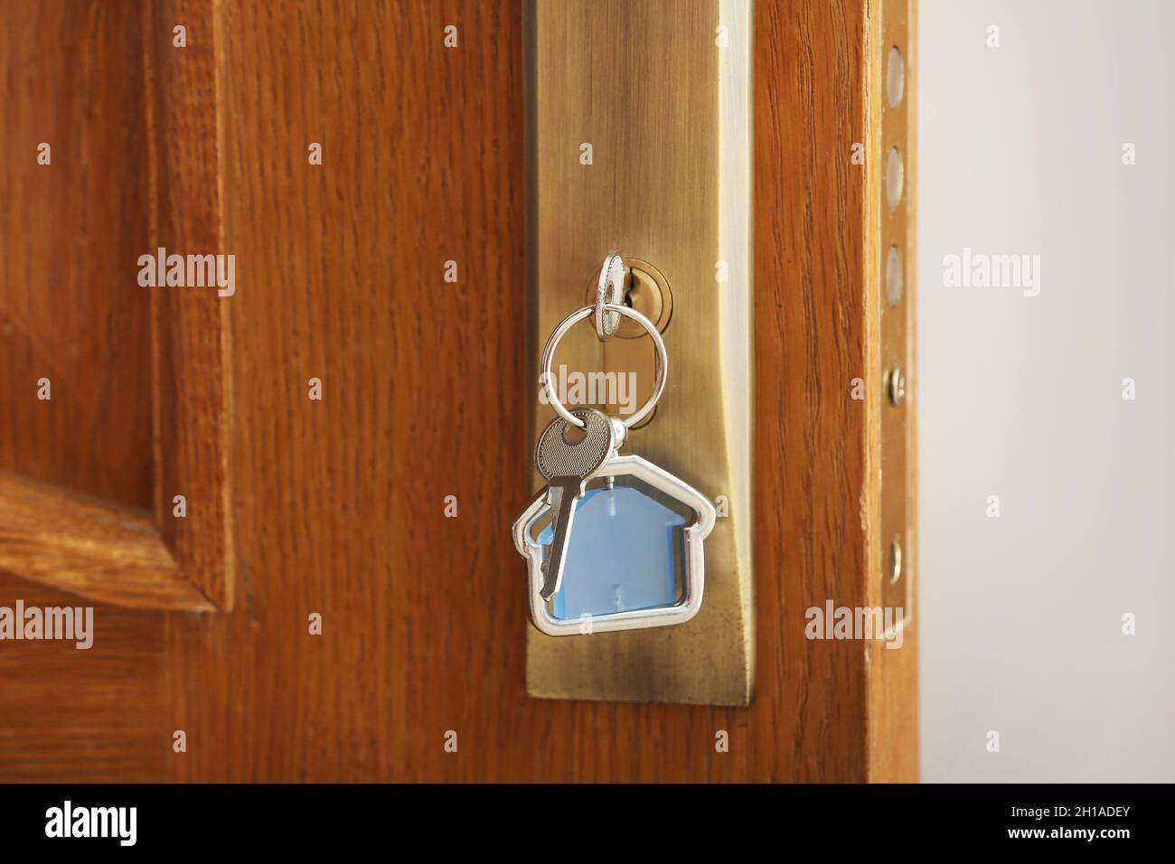 Key from house with keychain in door lock, closeup Stock Photo - Alamy