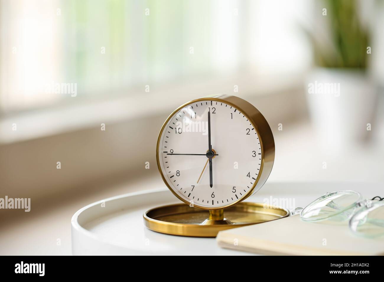 Alarm clock on table in living room Stock Photo - Alamy