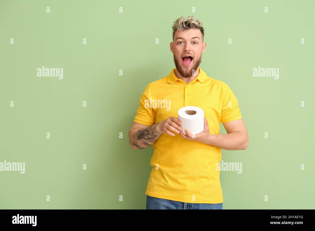 Happy young man with toilet paper on color background Stock Photo - Alamy