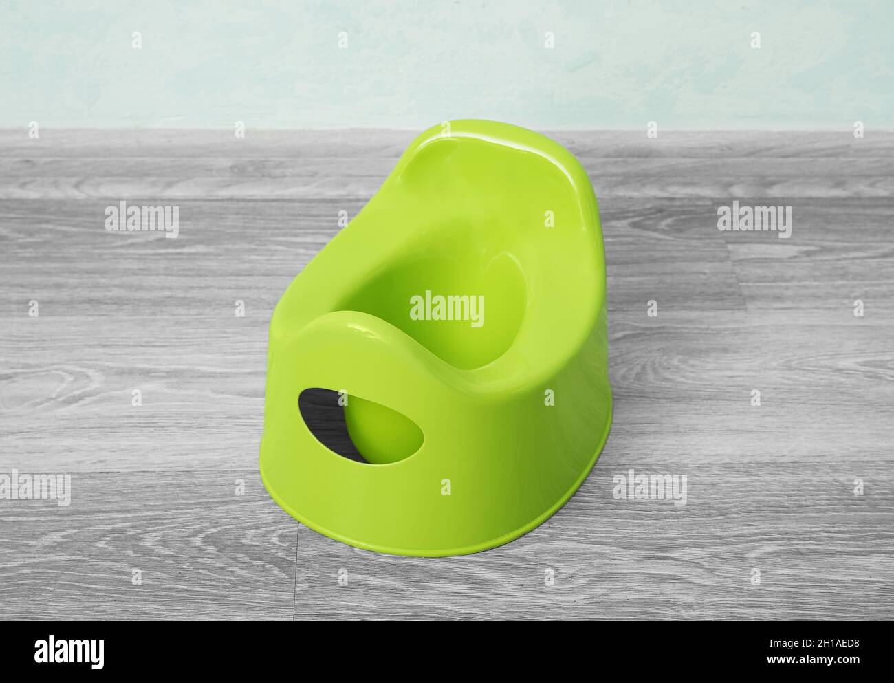 Green potty on grey wooden floor Stock Photo - Alamy