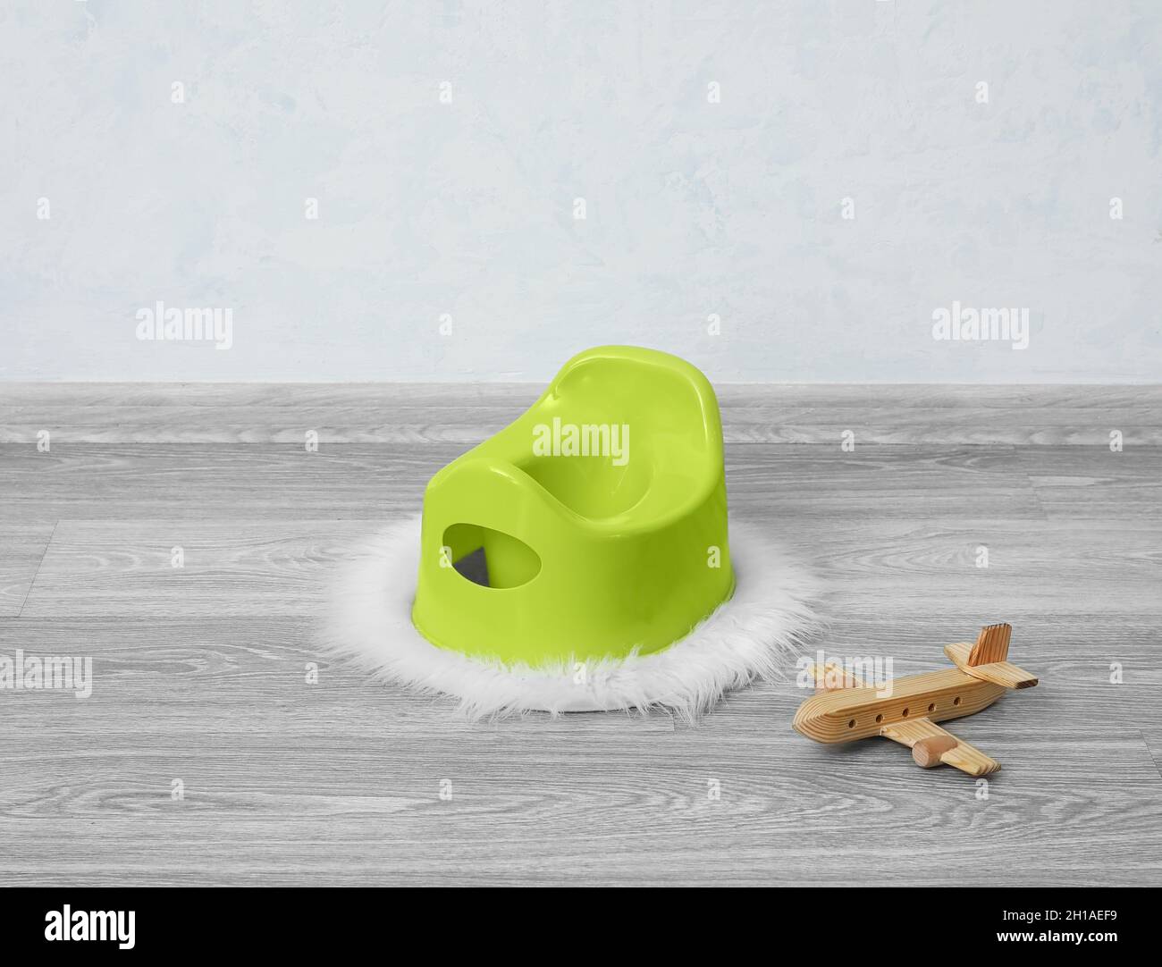 Potty and wooden plane on grey wooden floor near light wall Stock Photo ...