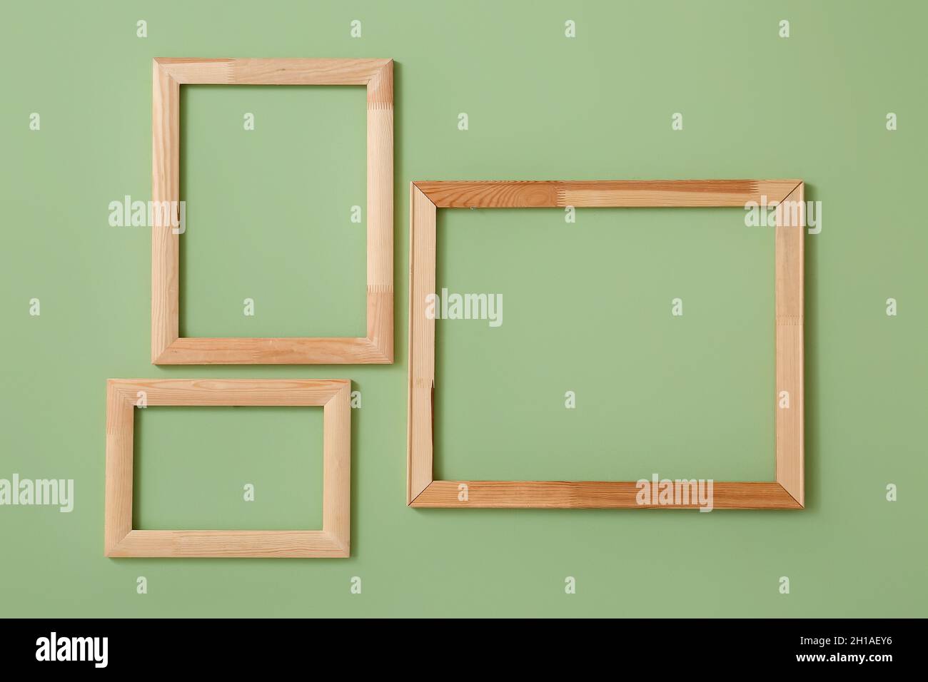 Wooden frames hanging on color wall Stock Photo - Alamy