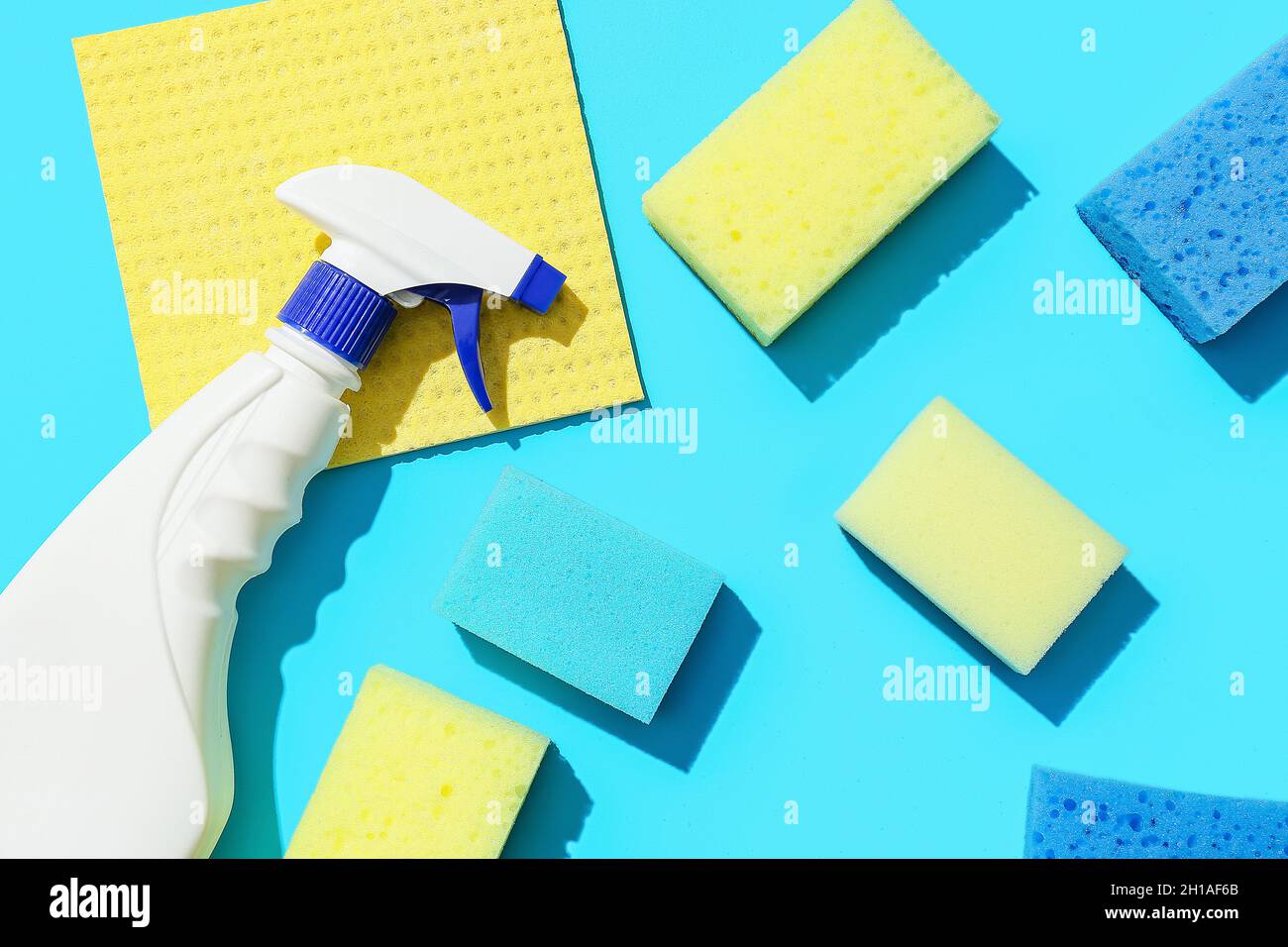 Cleaning sponges, rag and bottle of detergent on blue background Stock ...