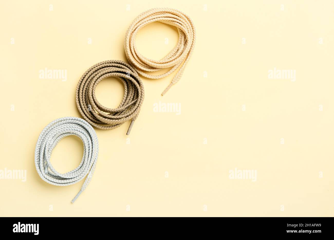 Rolls of different shoe laces on color background Stock Photo - Alamy
