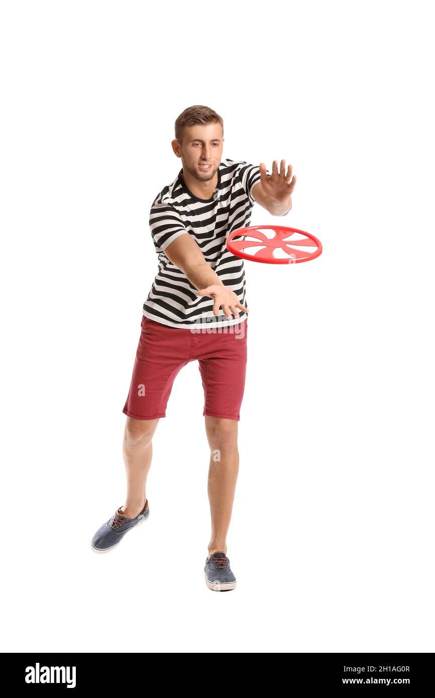 Young man catching frisbee on white background Stock Photo - Alamy