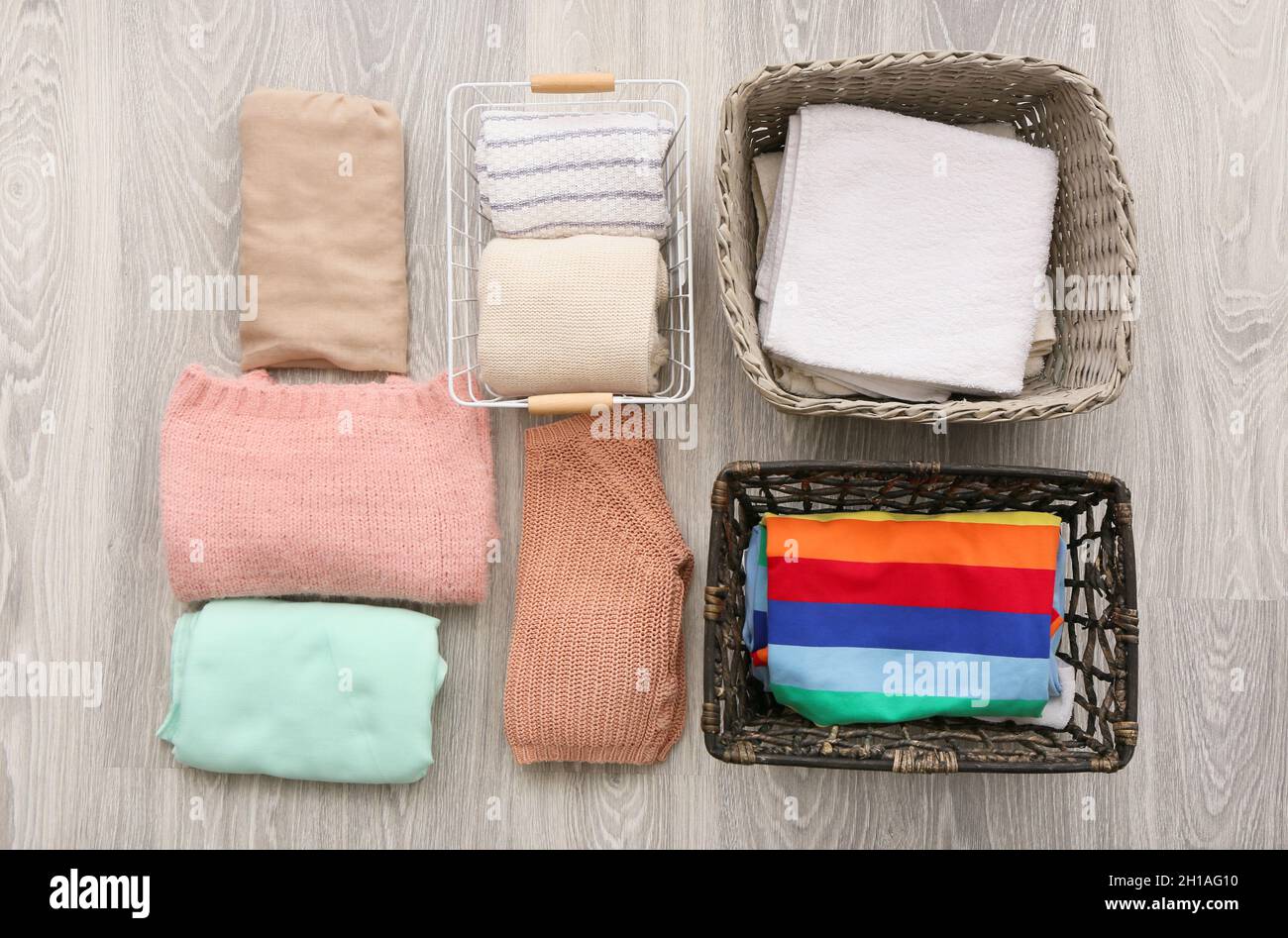 Different baskets and clean clothes on grey background, closeup Stock ...