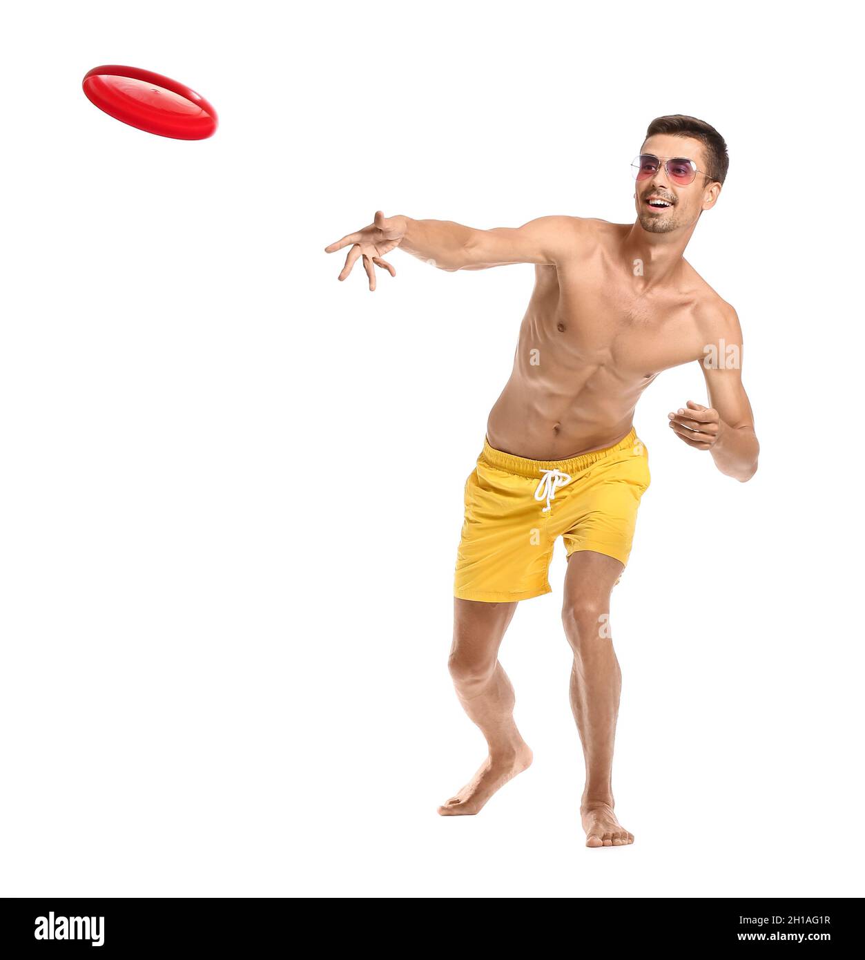 Young man throwing frisbee on white background Stock Photo - Alamy