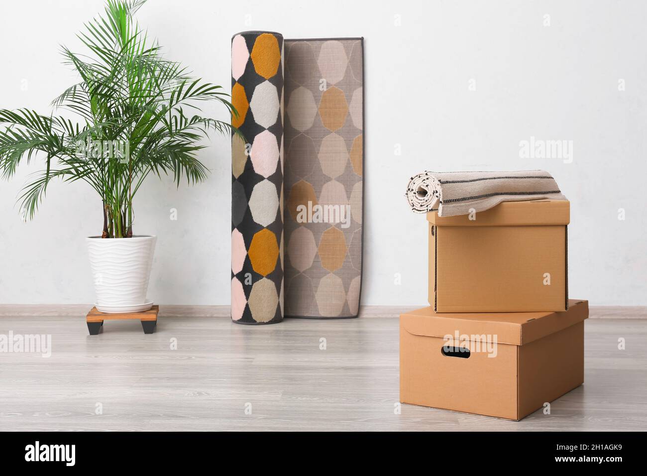 Cardboard boxes with rolled carpets in room Stock Photo - Alamy