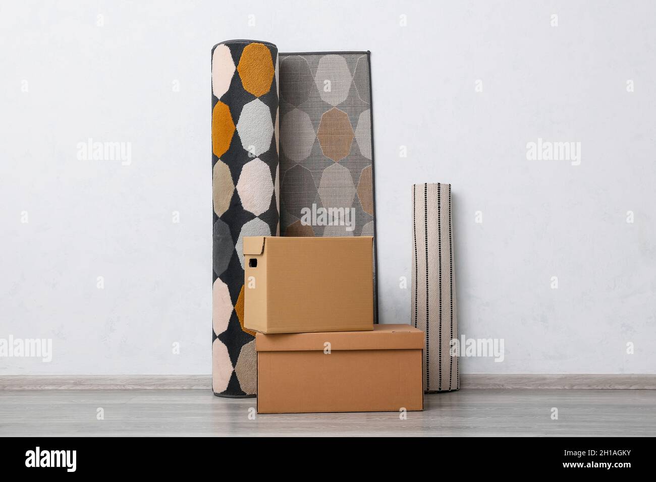 Cardboard boxes with rolled carpets in room Stock Photo - Alamy