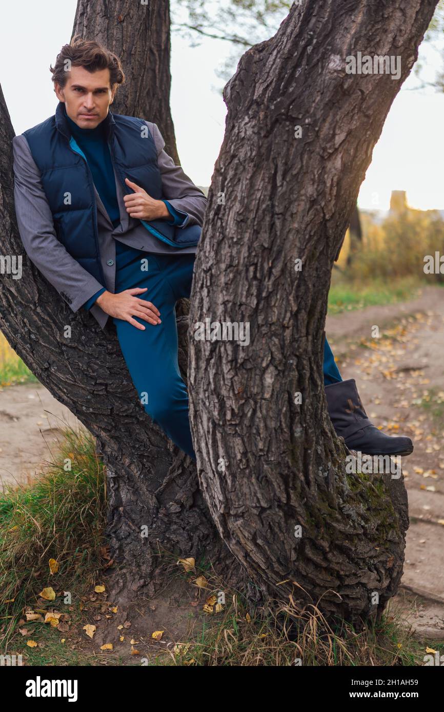Tall handsome man standing near the tree in yellow autumn forest Stock ...