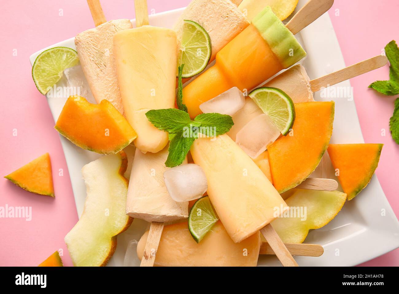 Plate with tasty melon popsicles on color background Stock Photo - Alamy