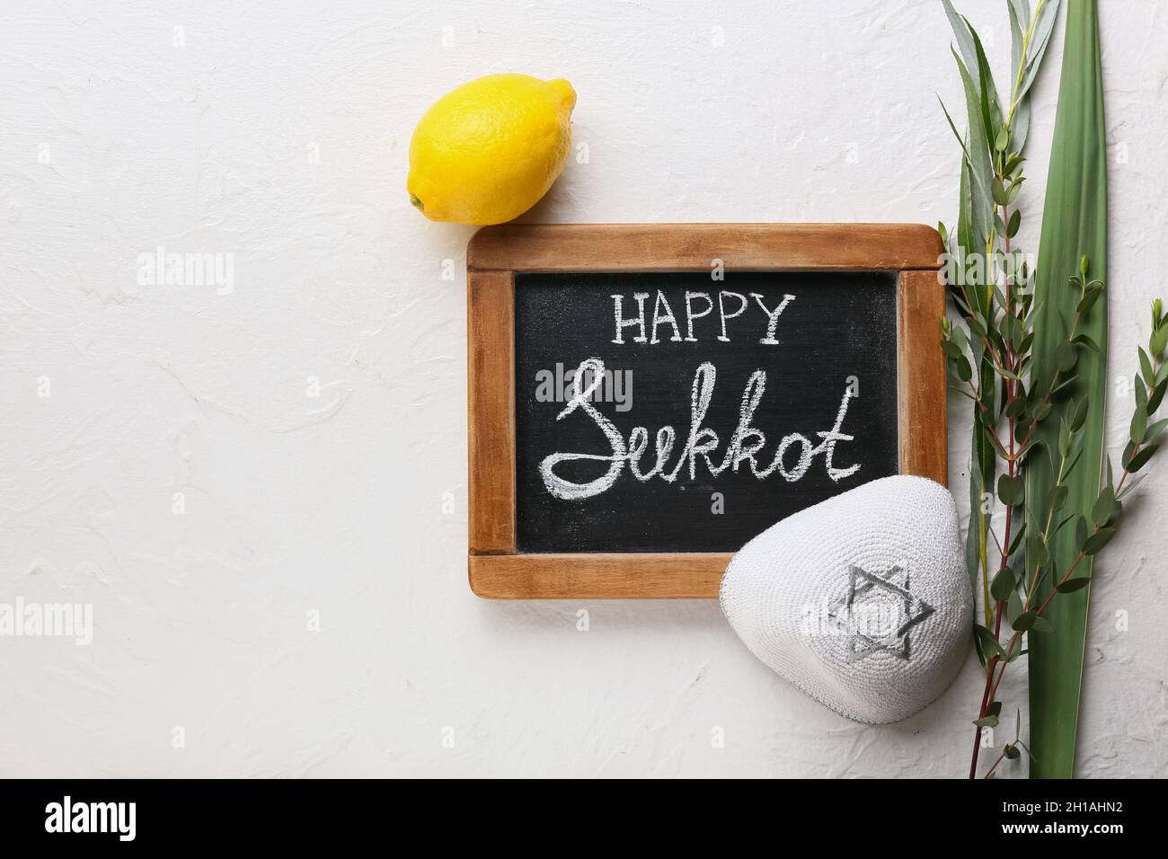 Chalkboard with text HAPPY SUKKOT and festival symbols on light ...