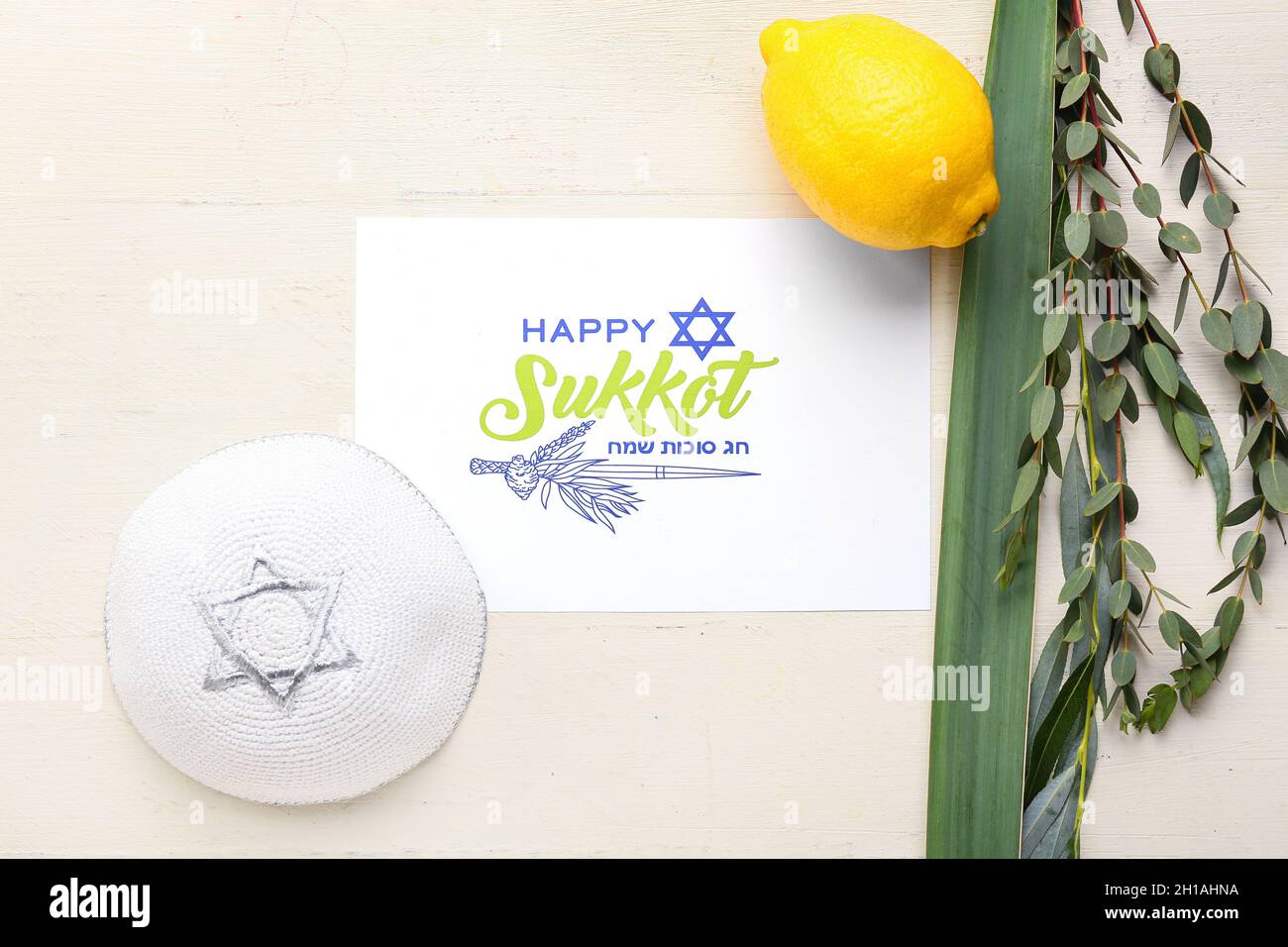 Sukkot festival symbols and greeting card on white wooden background ...