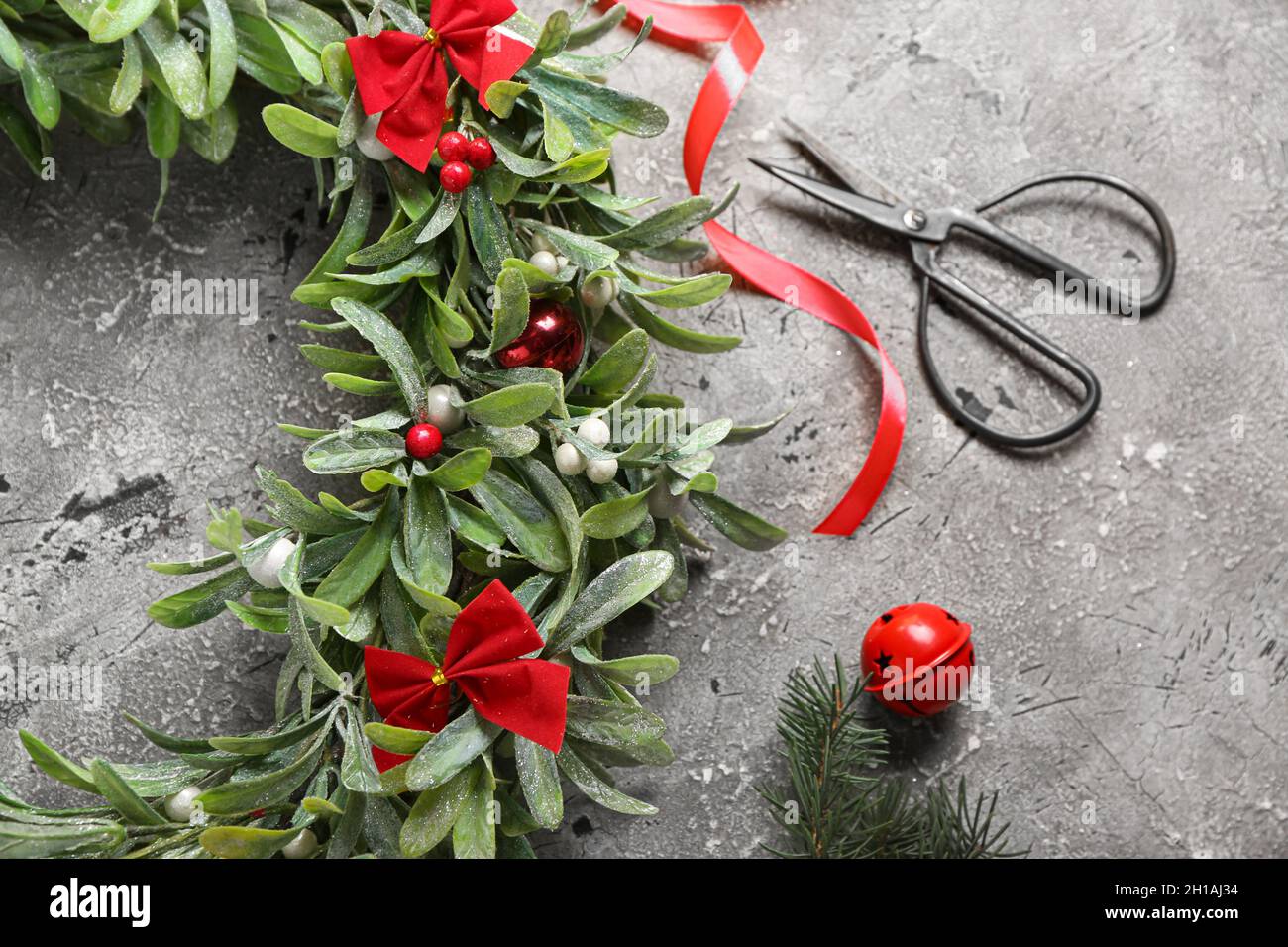 Beautiful mistletoe wreath and scissors on grunge background Stock ...