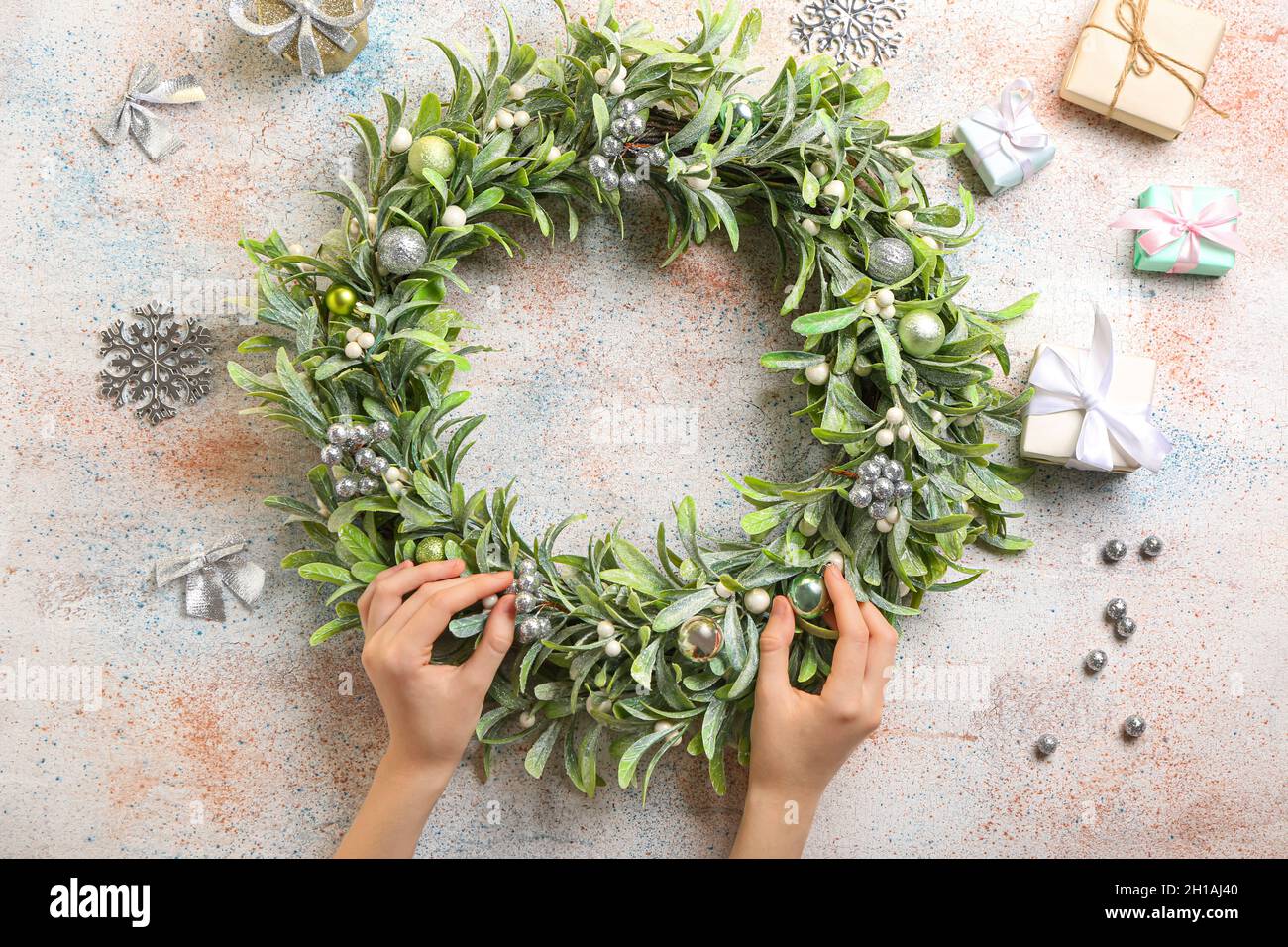 Woman decorated beautiful mistletoe wreath on grunge background Stock ...