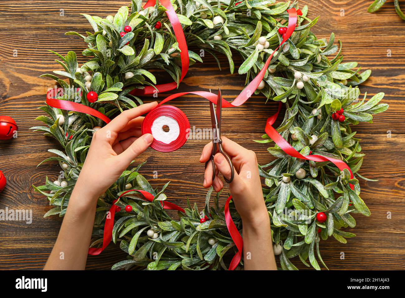 Woman decorated beautiful mistletoe wreath on wooden background Stock ...