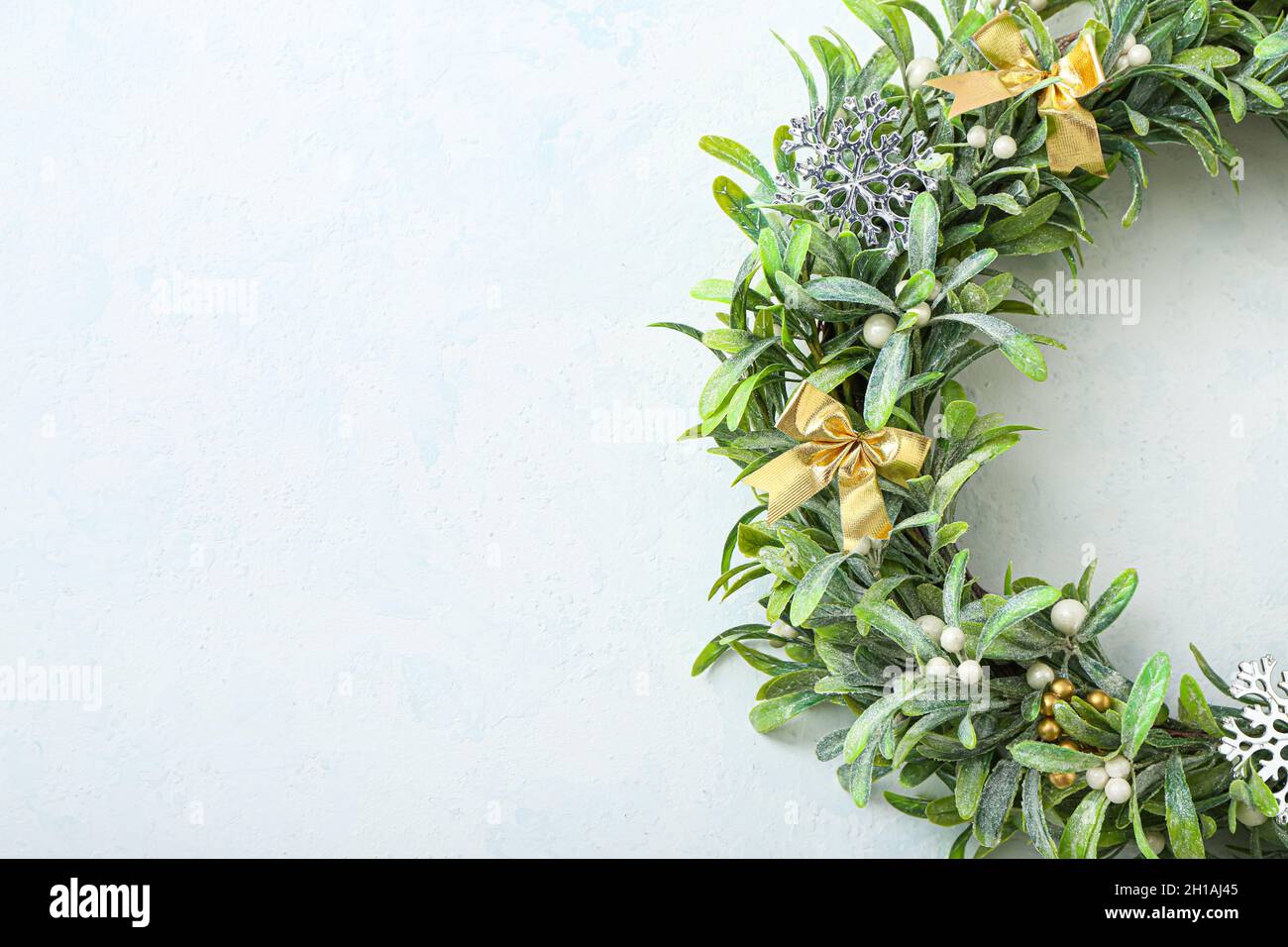 Beautiful mistletoe wreath on light wall Stock Photo - Alamy
