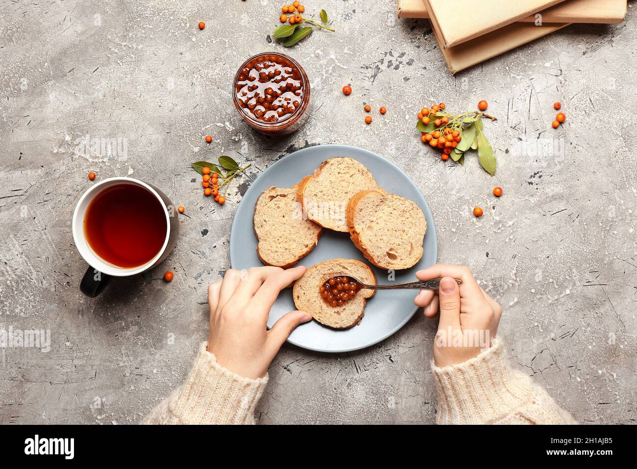 Woman eating healthy rowan berry jam with bread and tea, top view Stock ...