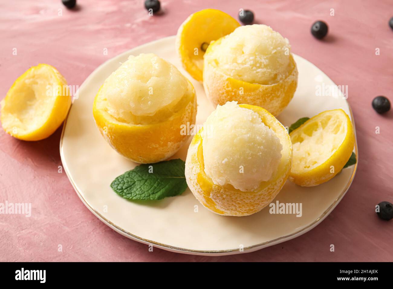 Plate with tasty ice creams in lemon peels on color background Stock ...