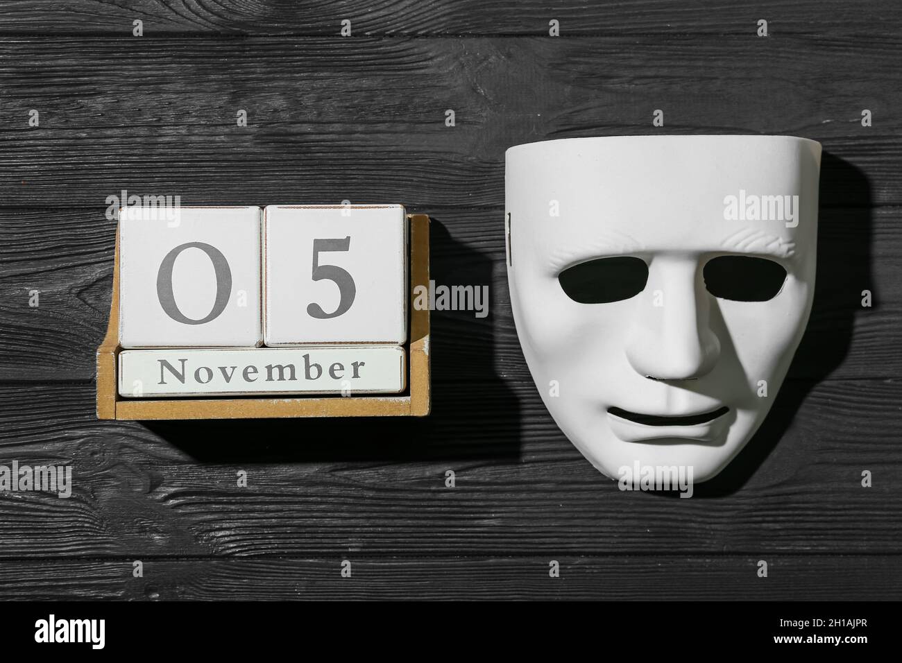 Guy Fawkes mask and calendar with date of November 5 on dark wooden ...