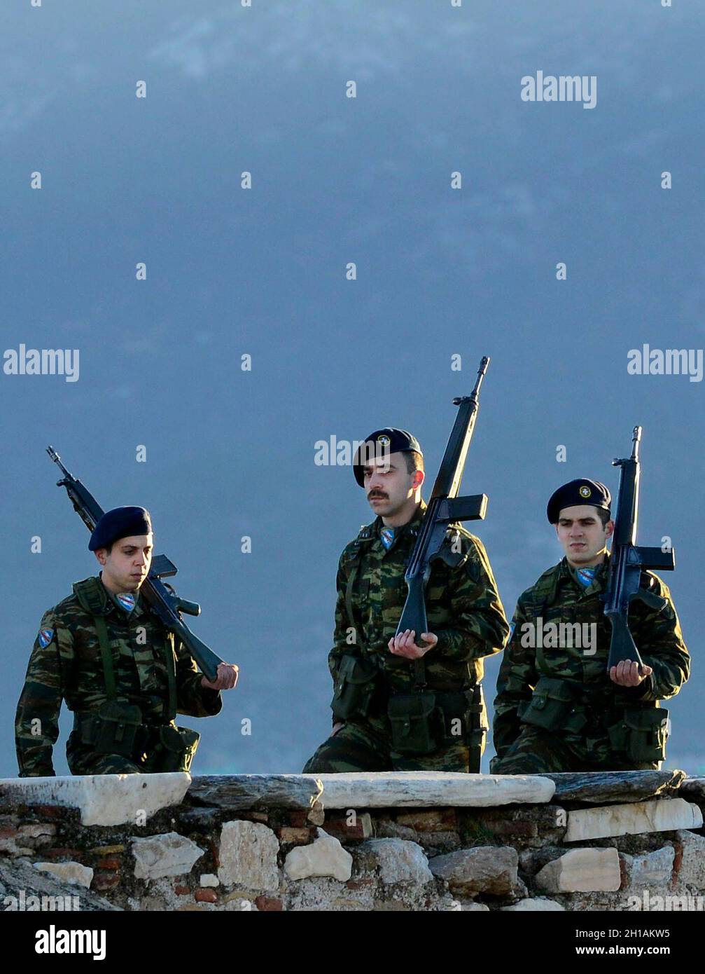 Greek solders saluting the Greek flag during the early morning flag ...