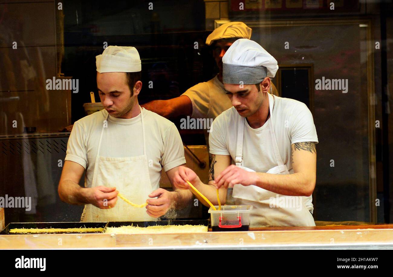 Pastry chefs working on a cheese covered Greek pastry Stock Photo - Alamy
