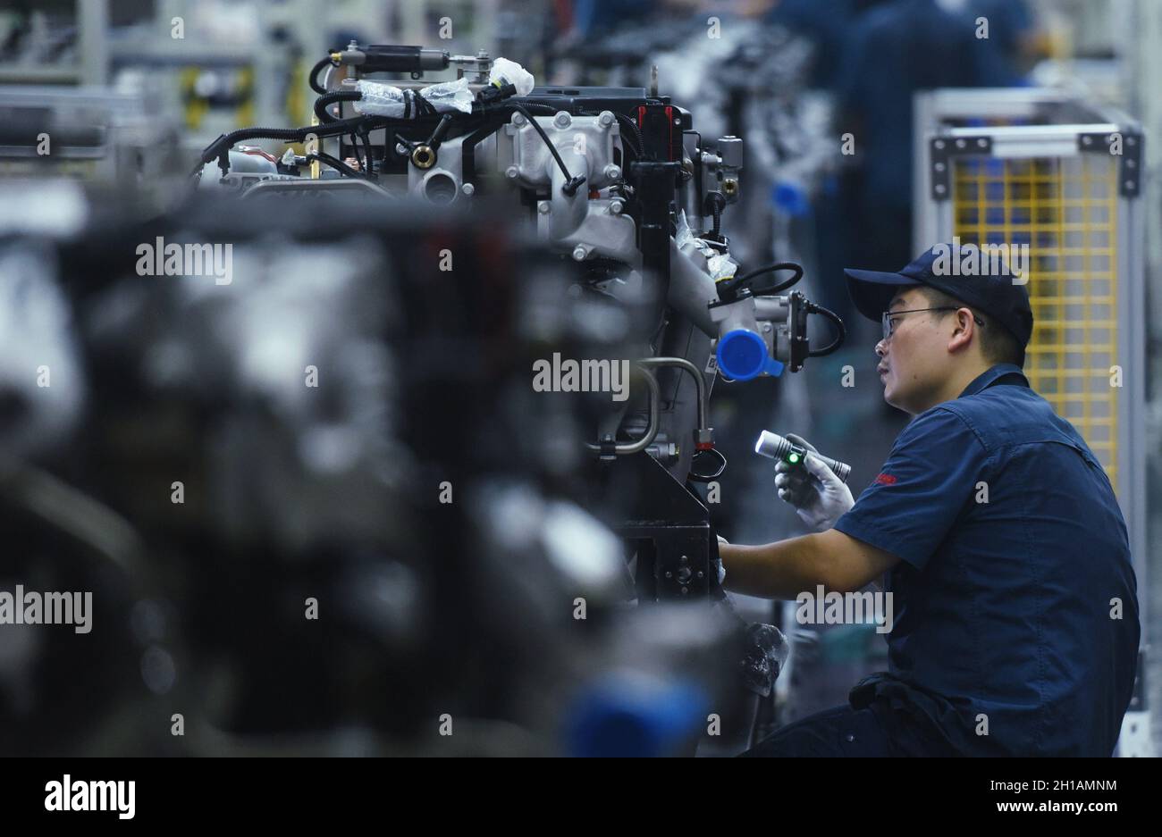 HANGZHOU, CHINA - OCTOBER 18, 2021 - A worker assembles heavy truck ...