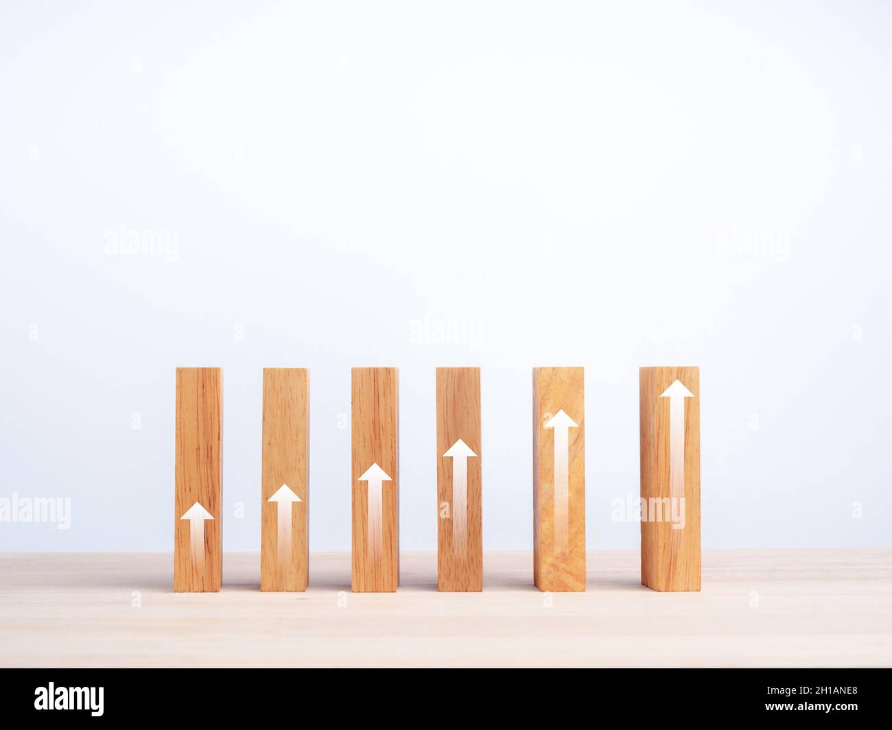 Rise arrows on wooden sticks chart on a wooden desk and clean white ...