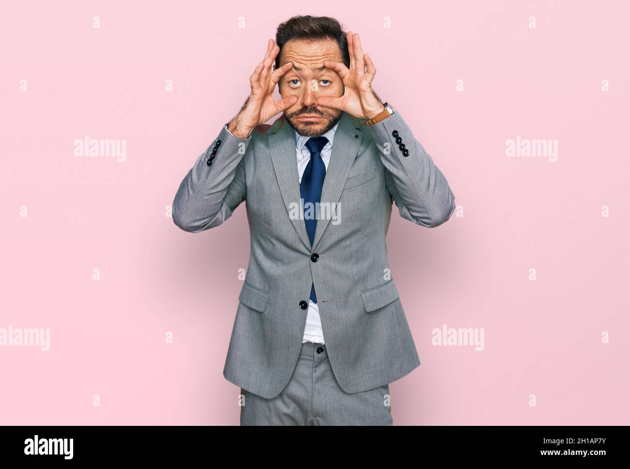 Middle age man wearing business clothes trying to open eyes with ...