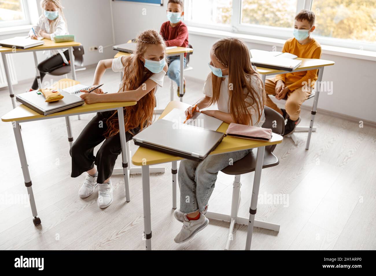Busy school kids with notebooks writing test together Stock Photo - Alamy