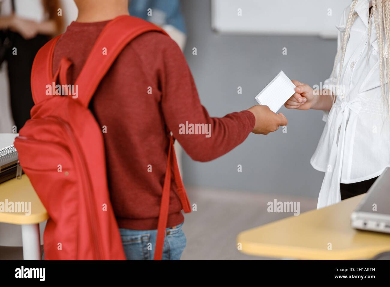 Boy passing paper note to girl at school Stock Photo - Alamy