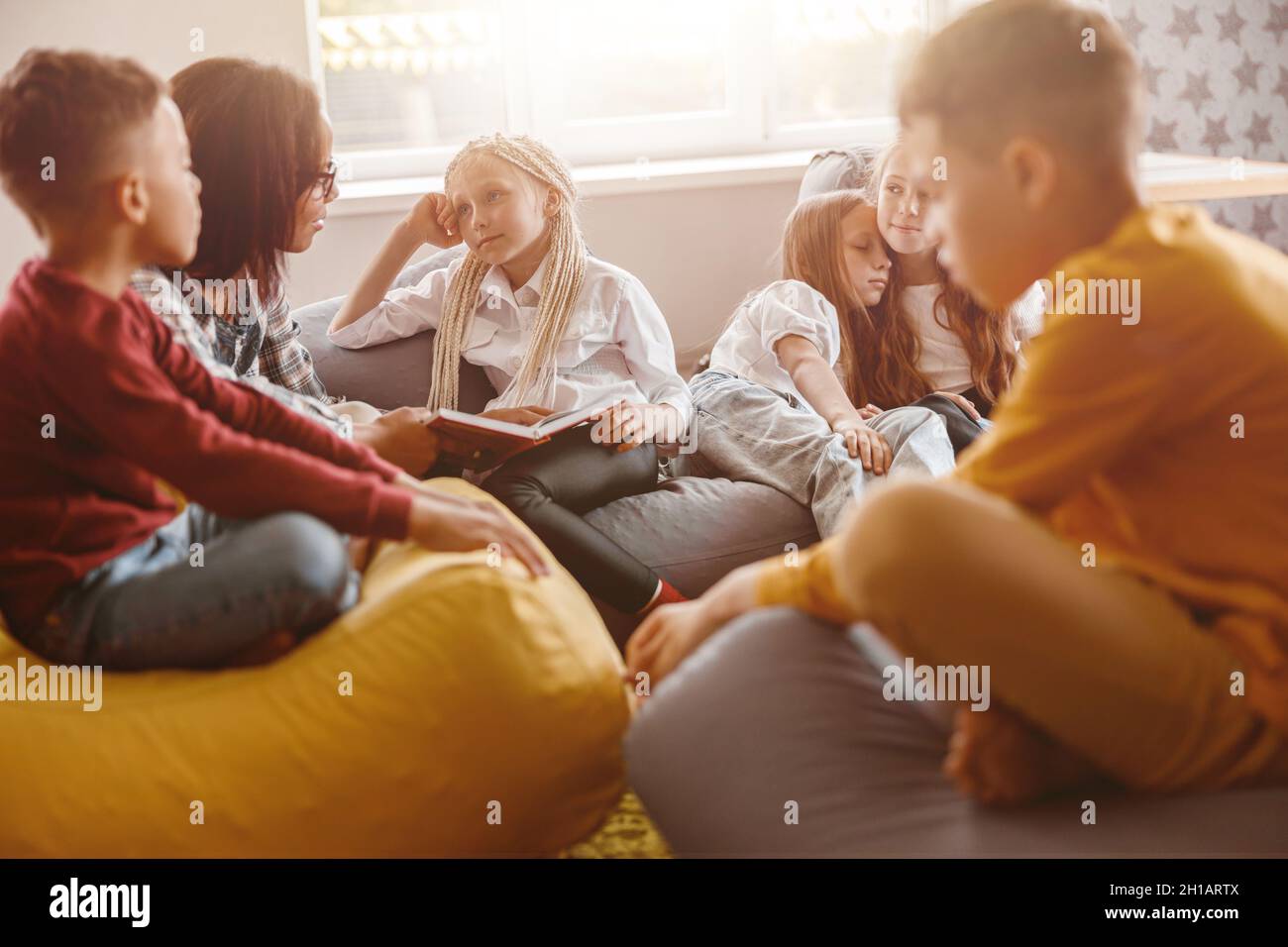 Female teacher holding a book during lesson Stock Photo - Alamy
