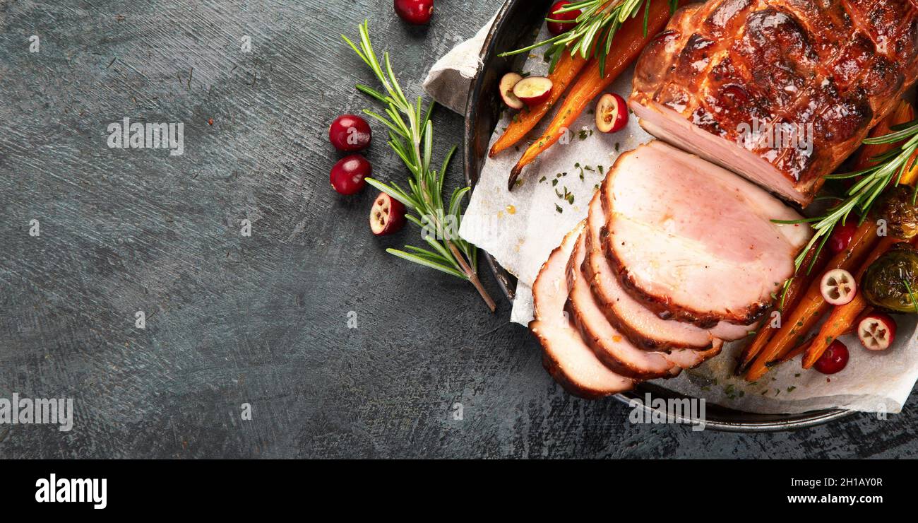 Baked ham with vegetables on dark background. Traditional food concept ...
