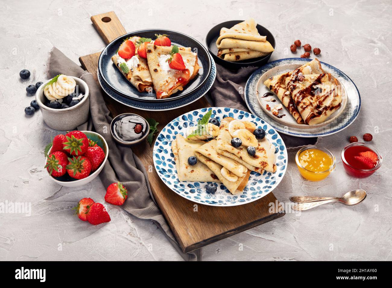 Sweet crepes assortment with berries chocolate on gray background. Homemade food concept Stock ...